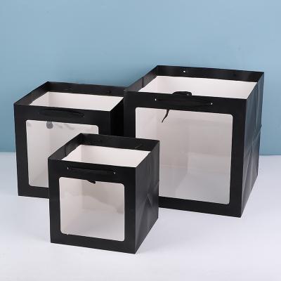 China Elegant Black Gift Bags With Clear Window Premium Kraft Paper Hand Carry Bags For Luxury Packaging for sale