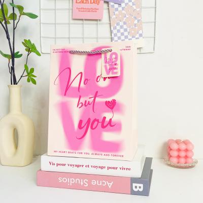 China Gift Bag Set Premium Textured Cardboard Packaging Rope Handle Design Romantic Love Messages for sale