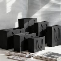 China Black Cardboard Bag Custom Paper Tote Packaging Bag Black Kraft Paper Bag Clothing Store Tote Bag for sale
