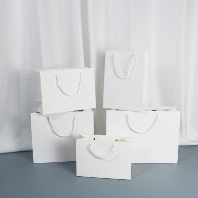 China Solid Color Paper Bag With Logo Printing Thick White Card Shopping Gift Bag Clothing Store Handbag for sale