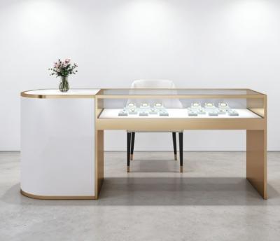 China Modern L-Shape Jewelry Display Table LED Lighting White Curved Cabinet Gold Metal Frame Glass Showcase for High-End Retail Store for sale