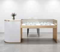 China Modern L-Shape Jewelry Display Table LED Lighting White Curved Cabinet Gold Metal Frame Glass Showcase for High-End Retail Store for sale