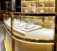 China Luxury Champagne Gold Curved Jewelry Display Counter, Modern Irregular Showcase with LED Lighting & Glass Top for sale