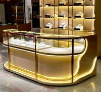China Luxury Champagne Gold Curved Jewelry Display Counter, Modern Irregular Showcase with LED Lighting & Glass Top for sale