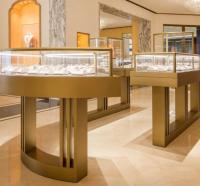China Luxury S-Shaped Curved Jewelry Display Cabinet | Brushed Gold Metal Frame Marble Accents | Glass Showcase Mall Showrooms for sale