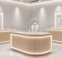 China Rounded Corner Island Jewelry Display Counter | Light Wood Body Gold Trim Glass Showcase | Built-in LED Lights High Showroom for sale
