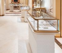 China Luxury Modern Curved Jewelry Display Island with Gold Metal Frame LED Lighting Quilted White Base for Mall Use for sale