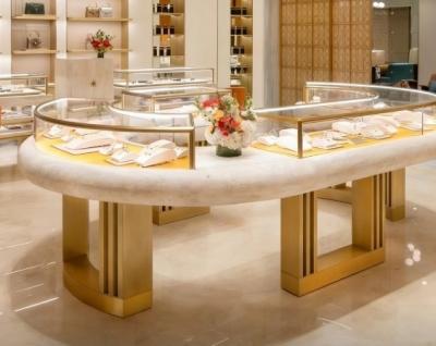 China Modern Freestanding Jewelry Display Counter Marble Top Curved Glass Showcase Decorative Gold Legs LED Lighting Retail Showroom for sale