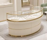 China Curved Arc High Quality Jewelry Display Counter | Cream Body Gold Trim | Glass Showcase LED Lights Retail Store Shopping Mall for sale