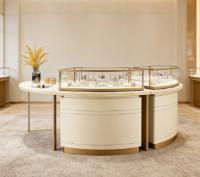 China Luxury Curved Reception Jewelry Display Counter | Beige Body Brushed Gold Frame Side Table | Curved Acrylic/Glass Showroom for sale