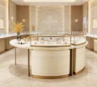 China Luxury Curved Reception Jewelry Display Counter | Beige Body Brushed Gold Frame Side Table | Curved Acrylic/Glass Showroom for sale