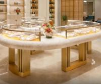 China Modern Freestanding Jewelry Display Counter Marble Top Curved Glass Showcase Decorative Gold Legs LED Lighting Retail Showroom for sale
