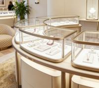 China Curved Single Jewelry Display Showcase LED | Cream Color Gold Metal Edging | Rounded Corner High-End Jewelry Boutique for Mall for sale