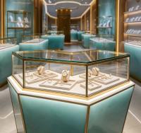 China Exclusive Jewelry Retail Space with Textured Wallpaper and LED Spotlights in White and Gold Color Scheme for sale