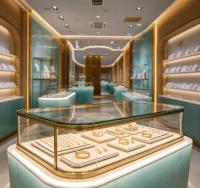 China Exclusive Jewelry Retail Space with Textured Wallpaper and LED Spotlights in White and Gold Color Scheme for sale