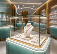China Exclusive Jewelry Retail Space with Textured Wallpaper and LED Spotlights in White and Gold Color Scheme for sale