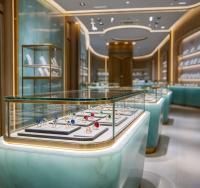 China Exclusive Jewelry Retail Space with Textured Wallpaper and LED Spotlights in White and Gold Color Scheme for sale