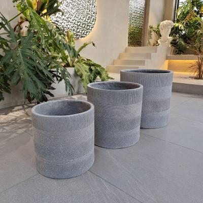 China Quangui Fiber Clay Planter Hand Carved Round D450 H450 with Drainage Holes for sale