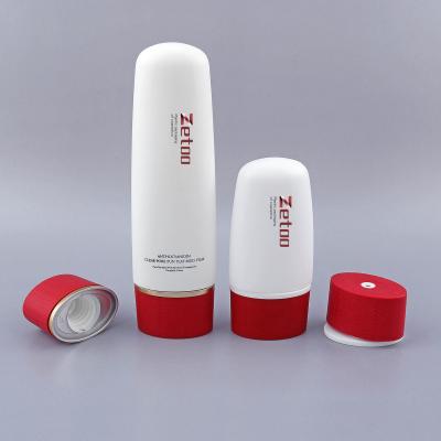China 50ml 100ml Oval PE Cosmetic Bottle Soft Touch 40mm Center Dispensing Cap for sale