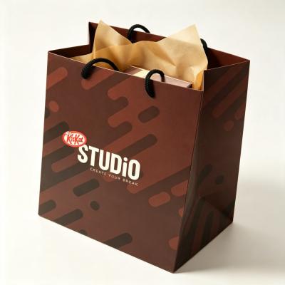China Recycled Gift Bags Vertical Paper Bags with Custom Printed Artwork and Black Rope Handles for Retail Packaging and Marketing for sale