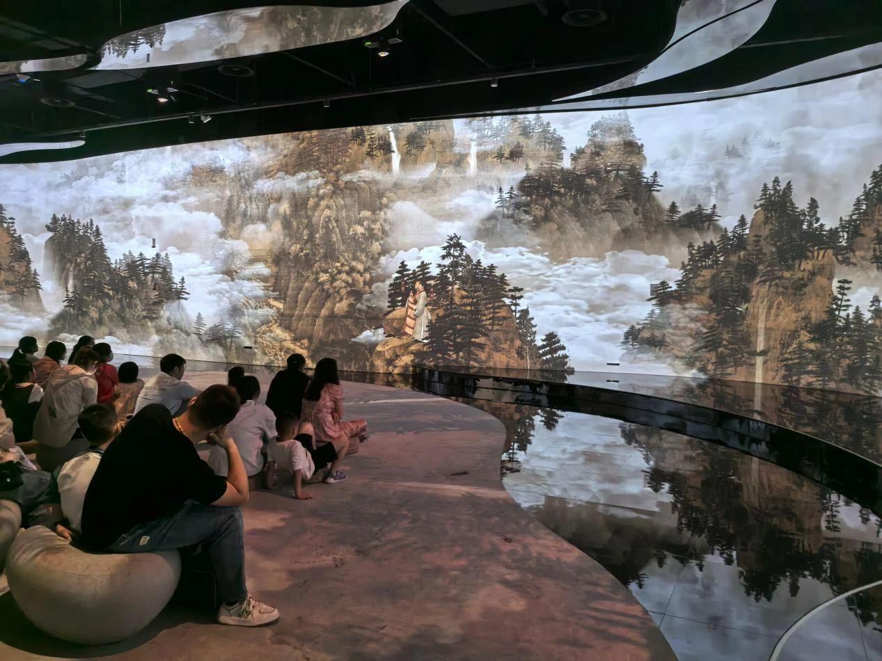 Exhibition space showing digital projections of classical Chinese paintings