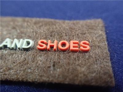 China Custom Non-Woven Garment Patch with 3D Injection Molding Double Color Logo 500 Pcs MOQ for sale