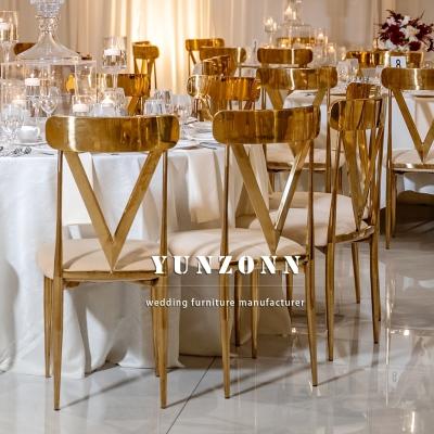 China New Design White Cushion Wedding Hotel Chair with Gold Stainless Steel V-Shaped Back for sale