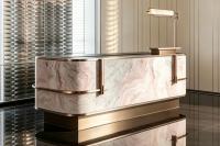 China Luxury Pink Onyx Marble Reception Desk with Bronze Metal Trim and Curved Design for Salon Front Counter for sale