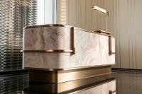 China Luxury Pink Onyx Marble Reception Desk with Bronze Metal Trim and Curved Design for Salon Front Counter for sale