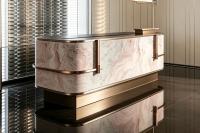 China Luxury Pink Onyx Marble Reception Desk with Bronze Metal Trim and Curved Design for Salon Front Counter for sale