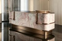 China Luxury Pink Onyx Marble Reception Desk with Bronze Metal Trim and Curved Design for Salon Front Counter for sale