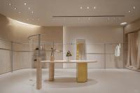 China Wabi Sabi Minimalist Women Clothing Store Interior Design with Natural Travertine Curved Wall and Multi-functional Zoning Layout for sale