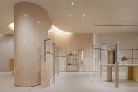 China Wabi Sabi Minimalist Women Clothing Store Interior Design with Natural Travertine Curved Wall and Multi-functional Zoning Layout for sale