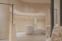 China Wabi Sabi Minimalist Women Clothing Store Interior Design with Natural Travertine Curved Wall and Multi-functional Zoning Layout for sale