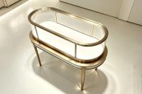 China Oval Curved Glass Jewelry Display Table with Slim Brushed Gold Metal Legs and Built-in LED Lighting for sale