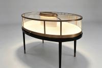 China Oval Jewelry Island Showcase with Bronze-Gold Frame and Raised Central Display Podium for 360-Degree Panoramic Viewing for sale