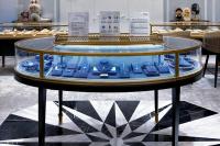 China Oval Curved Jewelry Island Showcase with Gold Metal Frame and LED Lighting for High-End Boutiques for sale
