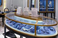 China Oval Curved Jewelry Island Showcase with Gold Metal Frame and LED Lighting for High-End Boutiques for sale