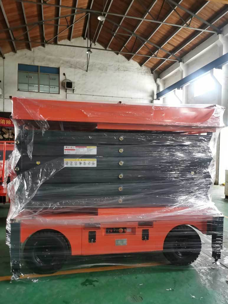 The equipment is tightly wrapped with moisture-proof film on all sides, and the stabilizing outriggers at the four corners of the chassis are clearly visible
