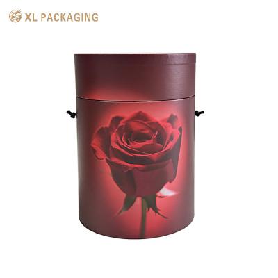 China Luxury Rose Flower Paper Tube Box with Custom Rose Artwork Black Rope Handle and Burgundy Red Matte Finish for sale