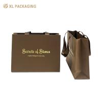 China Luxury Paper Gift Bag with Gold Foil Hot Stamping, Wide Satin Ribbon Handles, and Triangular Foldable Bottom for sale