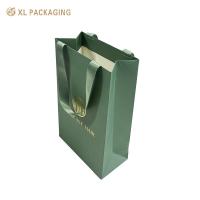 China Custom Gold Foil Logo Matte Sage Green Frosted Art Paper Gift Bag with Color-Matched Wide Satin Ribbon Handles for sale