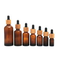 China Glossy Amber Color Bamboo Essential Oil Glass Dropper Bottle Wood Cap Glass Cosmetic Containers for sale