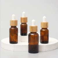 China Glossy Amber Color Bamboo Essential Oil Glass Dropper Bottle Wood Cap Glass Cosmetic Containers for sale