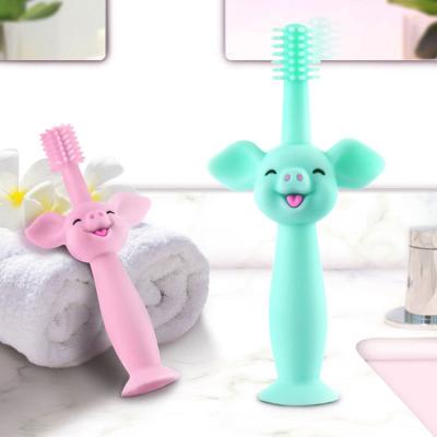 China Food Grade Silicone Baby Toothbrush Cartoon Pig Baby Teether Toy Soft Hair Oral Care Training Suction Base for sale
