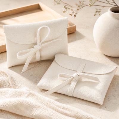 China Personalized Pu Leather Cosmetic Envelope Pouch With Bow High Quality Pu Leather Perfume Jewelry Cover Gift Bag for sale