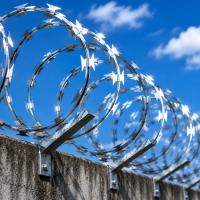 China Military Style Razor Barbed Wire Security Perimeter Fence Rusty Razor Barbed Wire Coil on Old Security Fence for sale