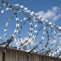 China Military Style Razor Barbed Wire Security Perimeter Fence Rusty Razor Barbed Wire Coil on Old Security Fence for sale