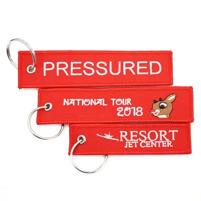 China Custom Remove Before Flight Keychain 130x30mm Red Embroidered Fabric with Key Ring for Aviation Promotions for sale