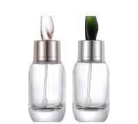 China Skin Care Serum Cream Bottles 15ml 30ml 50ml Clear Green Glass Designs with Stirring Stick Customizable for sale